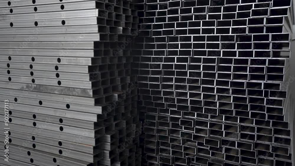 Metal pipes. Close view profile pipe laid in rows. Industrial machine ...