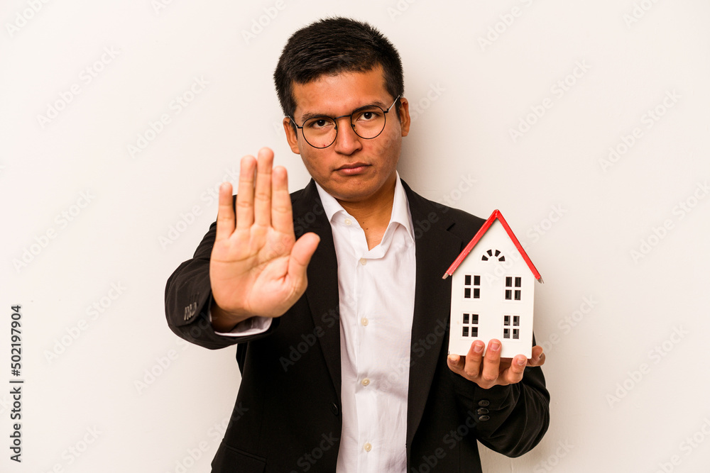 Young business hispanic man holding a little house isolated on white ...