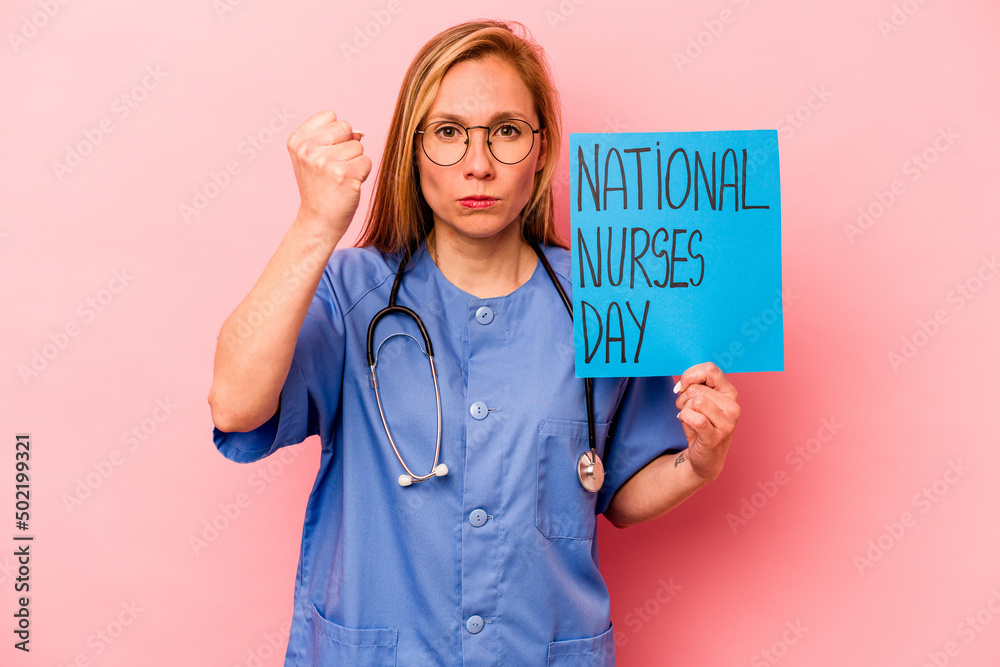 Young nurse woman holding nurse international day isolated on pink ...
