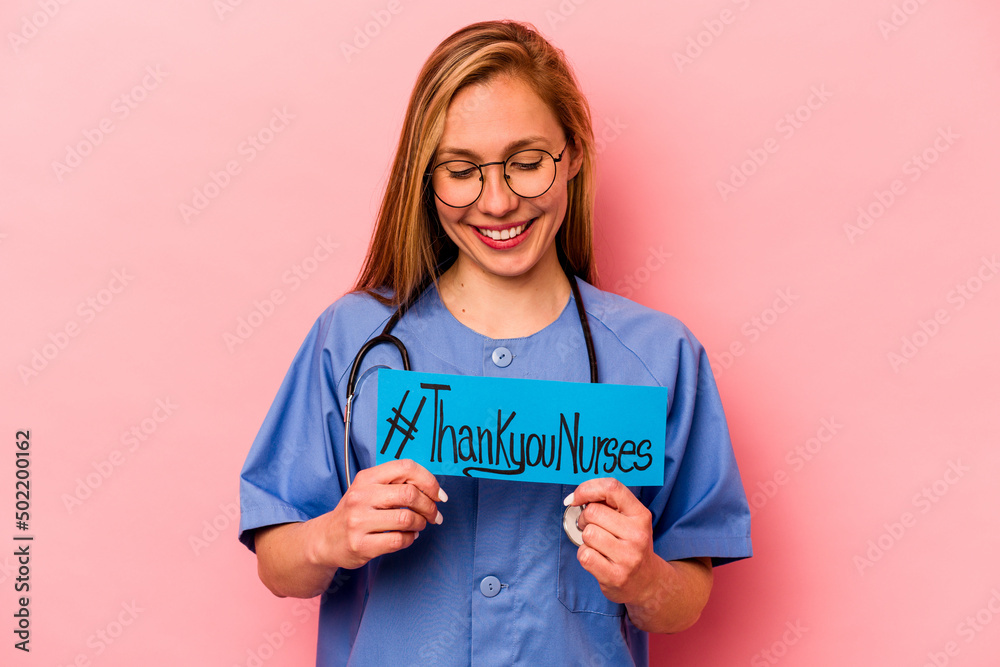 Young nurse woman holding thank you nurses placard isolated on pink ...