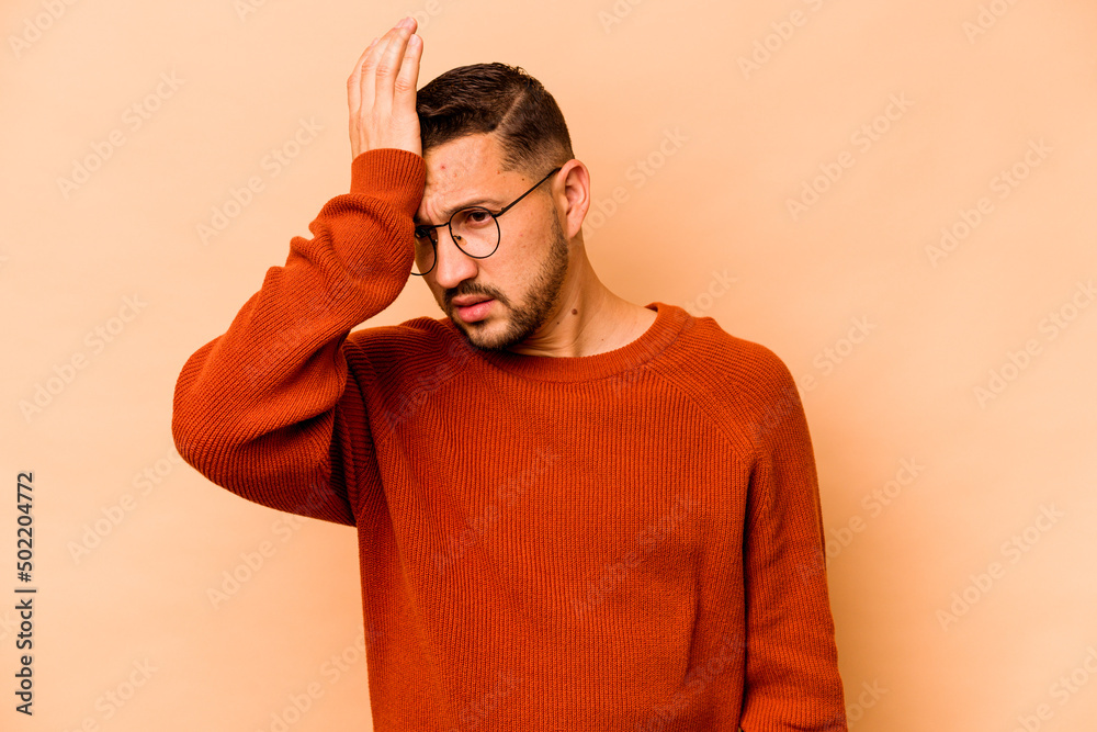 Young hispanic man isolated on beige background forgetting something ...