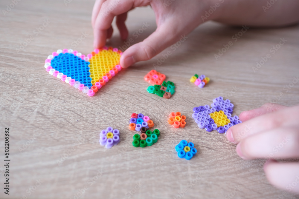 close-up of heart, children's hands creating perler bead patterns, make ...