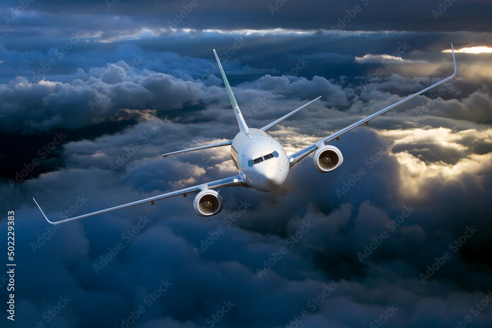 Naklejka Passenger plane in flight. Aircraft flies high in the blue sky ...