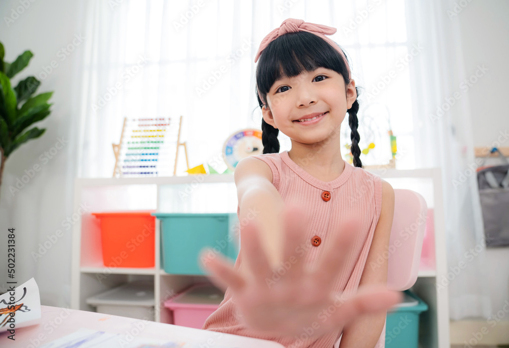 Pretty girls sitting in the kindergarten school classroom and showing ...