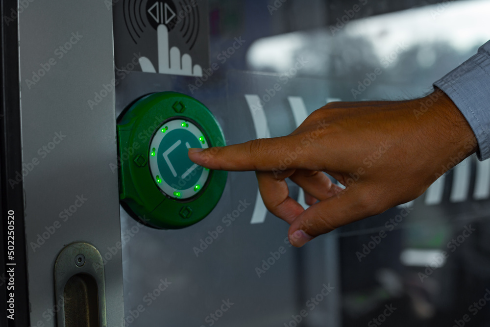 Foto de Man push green sensor button on transparent train door. Public ...