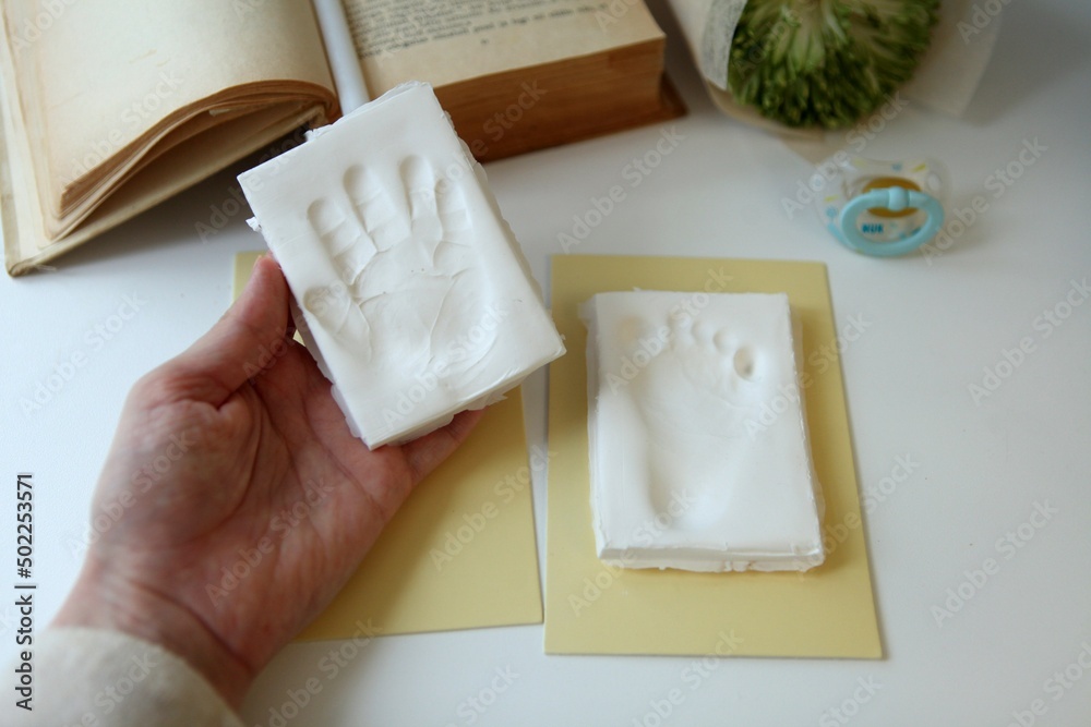 Baby handprint and footprint on womans hand with copy space. parents ...