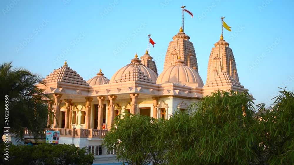 Hindu temple with flags on dome with clear blue sky. Spirituality ...