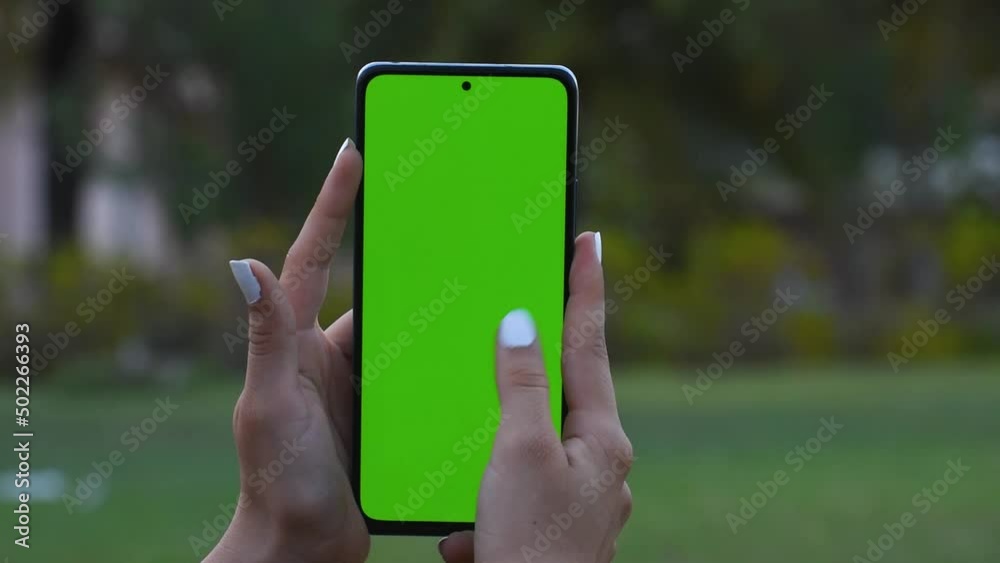 Vidéo Stock Closeup shot of female hand using mobile phone with Green ...