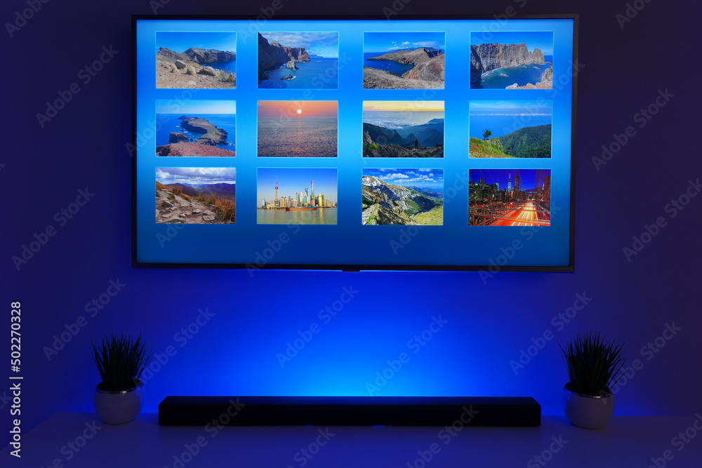 modern new smart TV with soundbar highlighted in blue LED light. On the ...