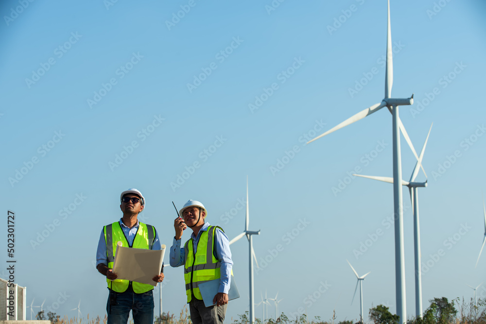 Couple Standing In Front Of Windmill Workers In The Wind Two