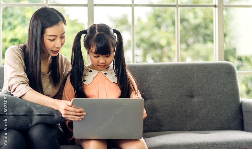 Mother and asian kid little girl learn and look at laptop computer ...