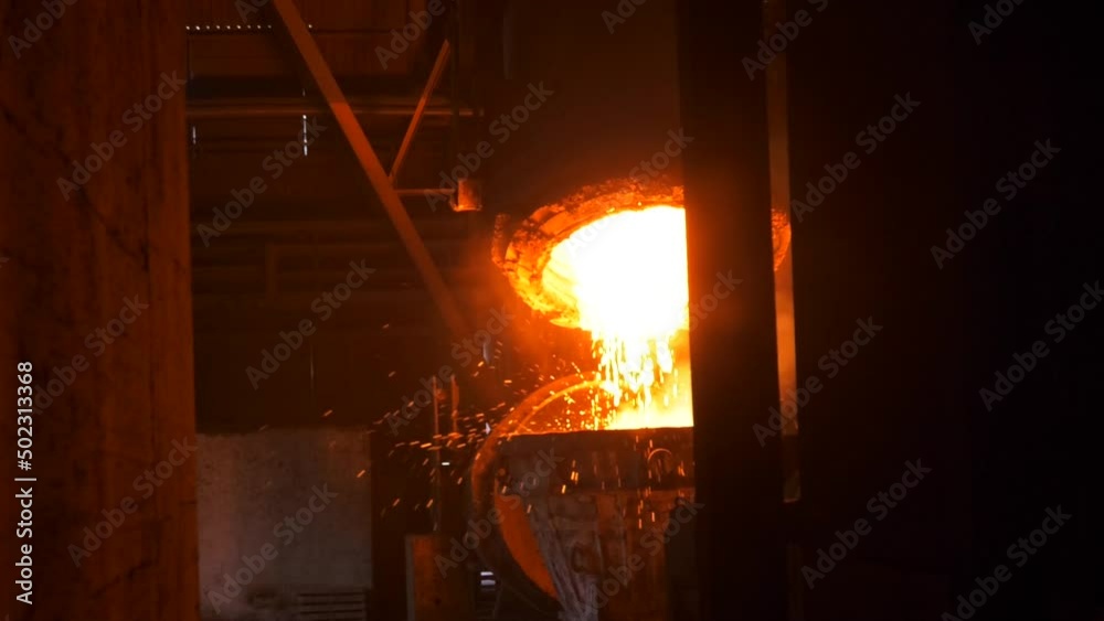 Molten iron pour from ladle into melting furnace. steel production in ...