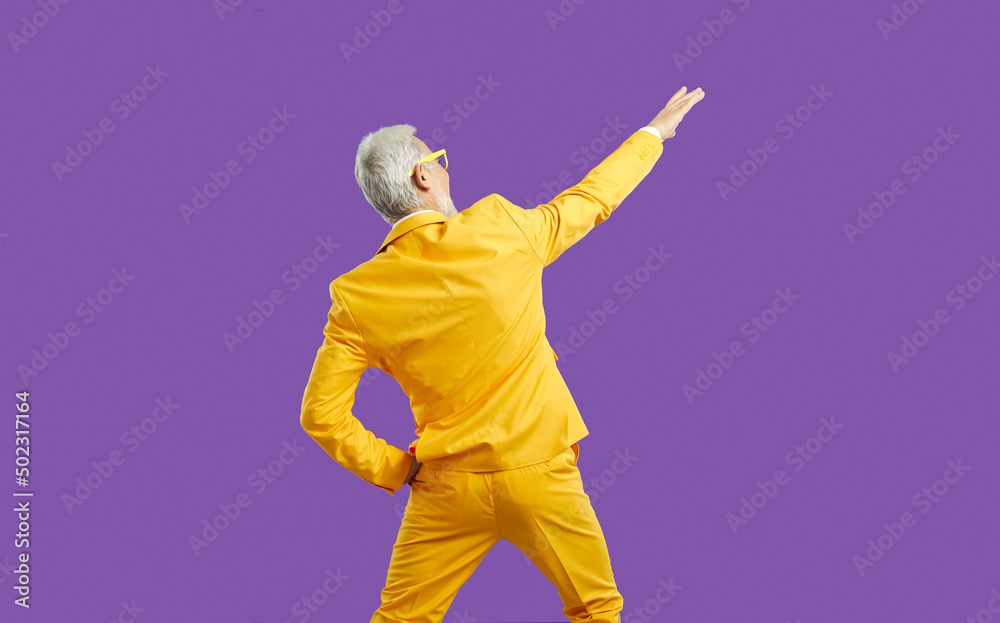 Back view of funny energetic senior man in stylish outfit having fun at ...