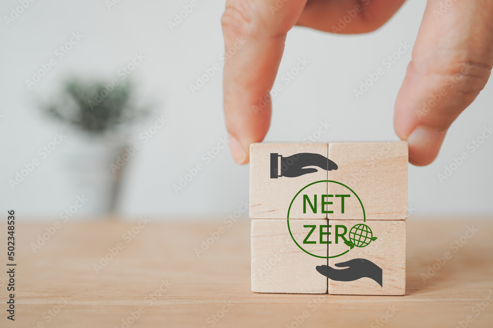 NET ZERO with earth icon instead of O alphabet over hand for health ...