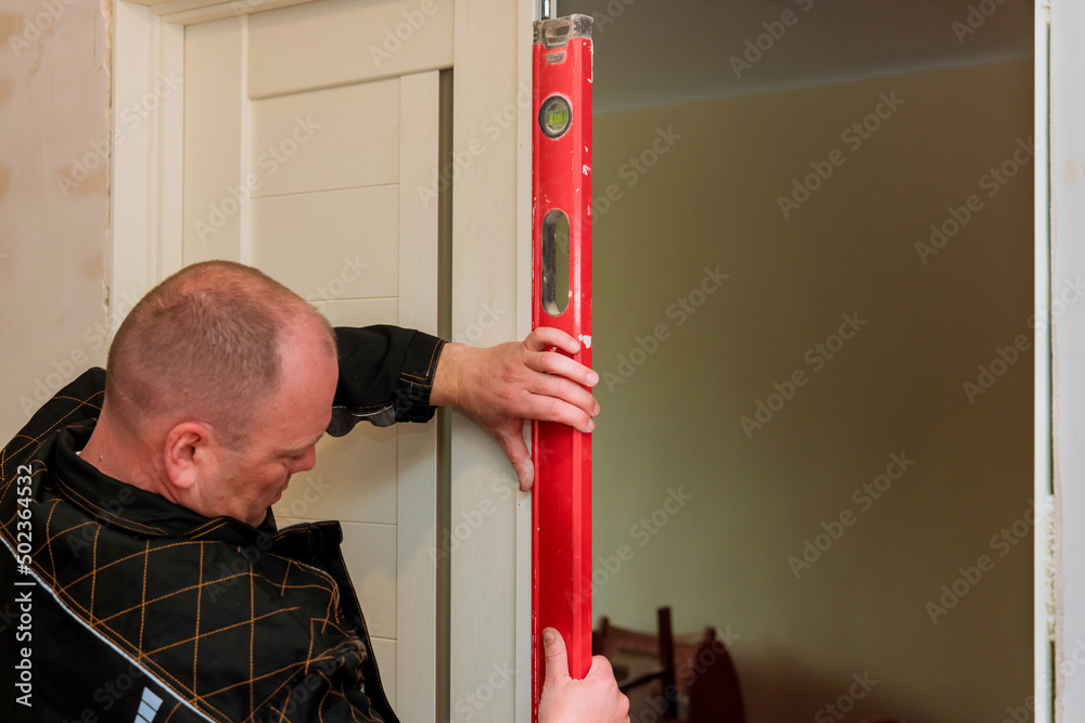 Man is installing the doors with checks level correctness installation ...