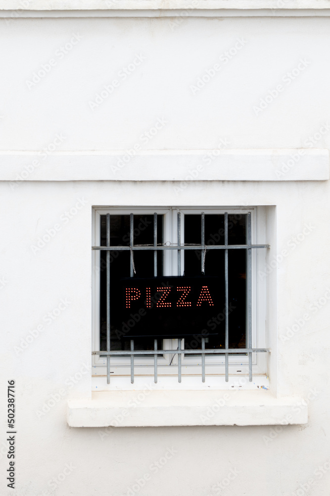 Window with Pizza sign outside white building Stock Photo | Adobe Stock