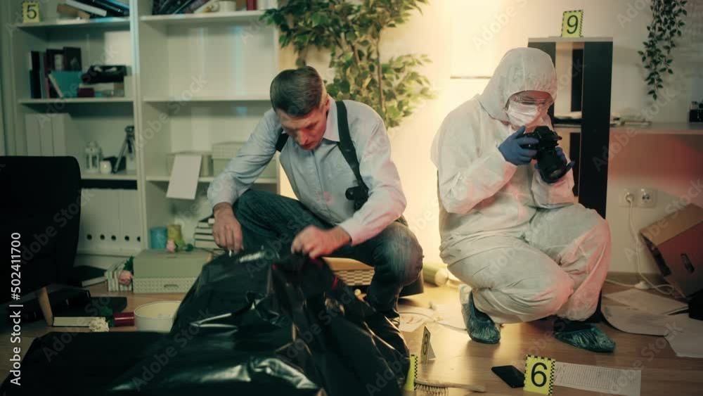 Crime lab worker talking with detective at crime scene, colleagues at ...
