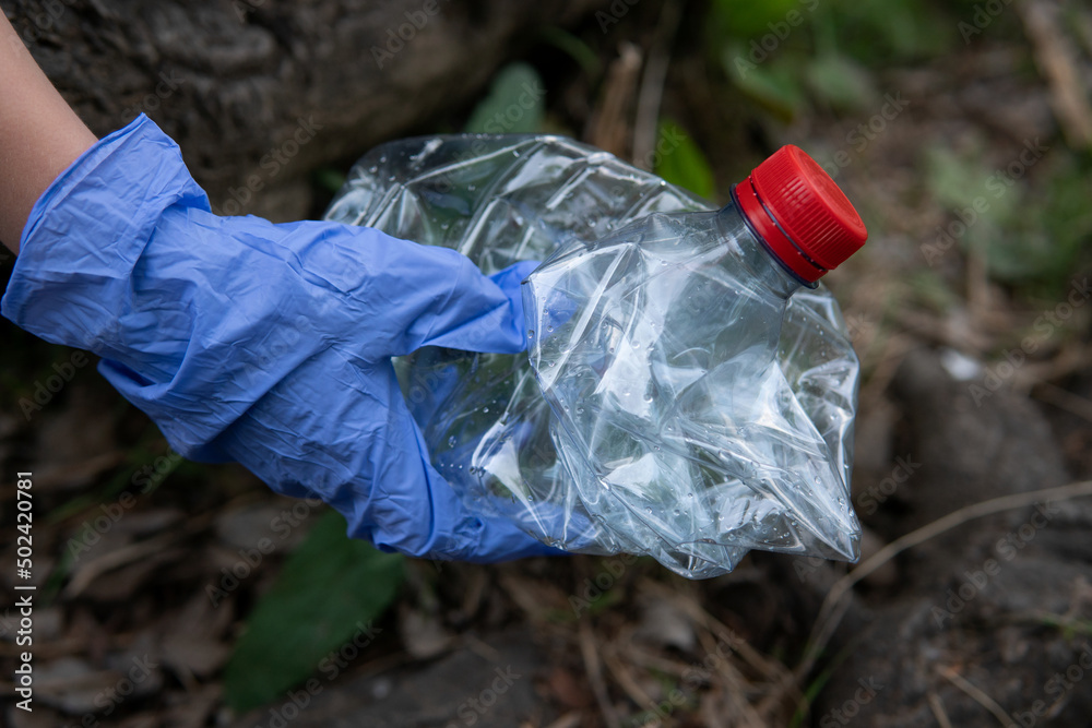 Gloved Hand Holding Crumpled And Used Plastic Bottle Hand Picking Up A Bottle Of Water Thrown