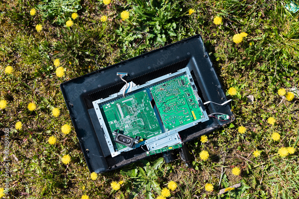 Broken waste garbage computer in the grass where nature takes over and ...