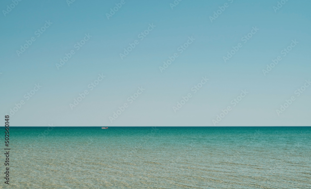 Sea panorama in shallow water with sun reflection in water, vast open ...
