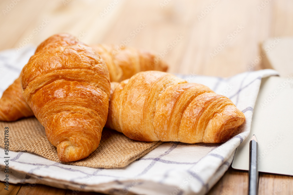 Two croissants are on plate. Croissant is a buttery, flaky, French ...