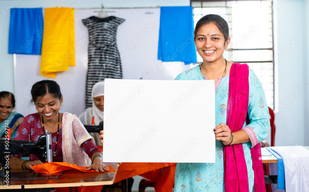 Smiling small business owner showing white empty sign board by looking ...