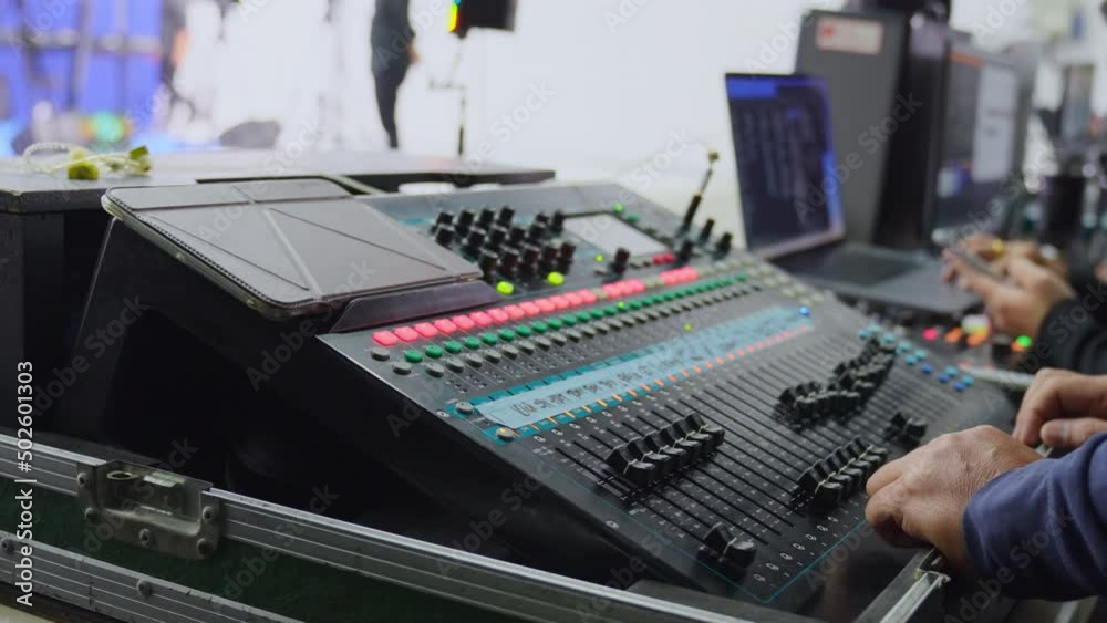 Selective focus of male sound engineer's hand sliding and pushing the ...