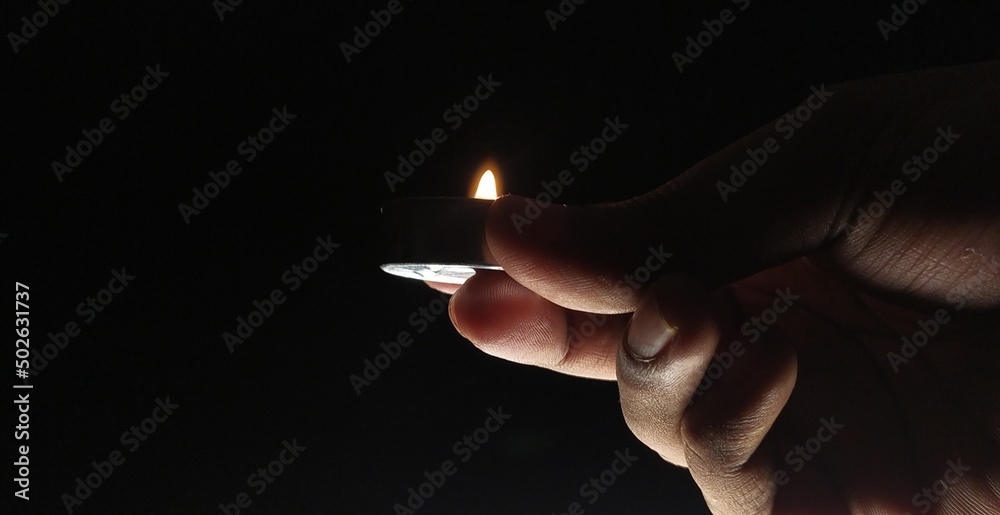 Hand fingers holding one lit burning small decorative oil lamp light ...