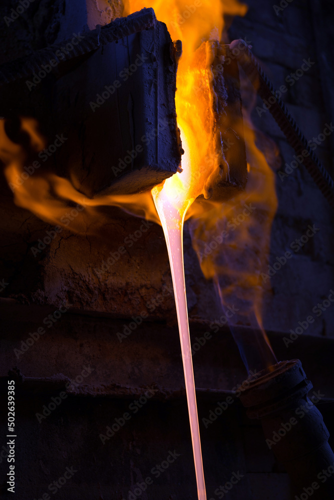 Melted glass furnace in glass factory.The melted glass flows from the ...