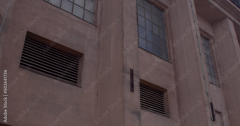 The facade of the prison building with windows and ventilation grilles ...