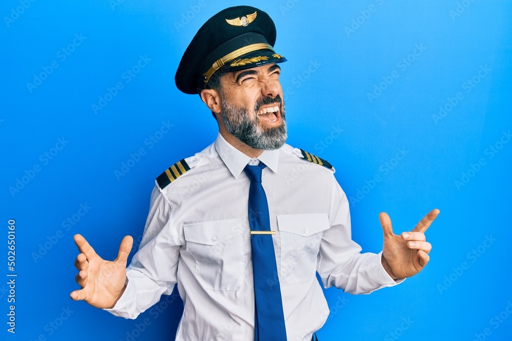 Middle age man with beard and grey hair wearing airplane pilot uniform ...