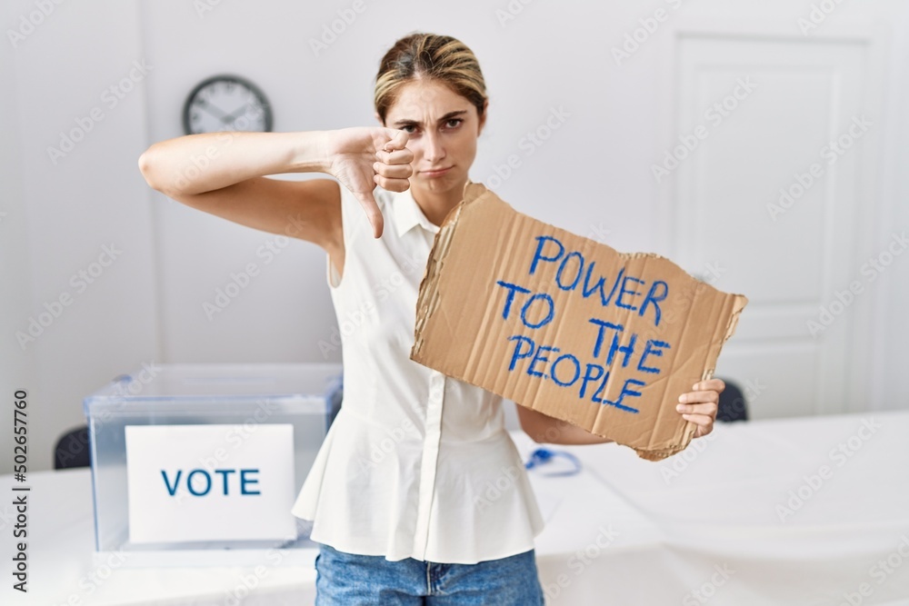 Young blonde woman at political election holding power to the people ...