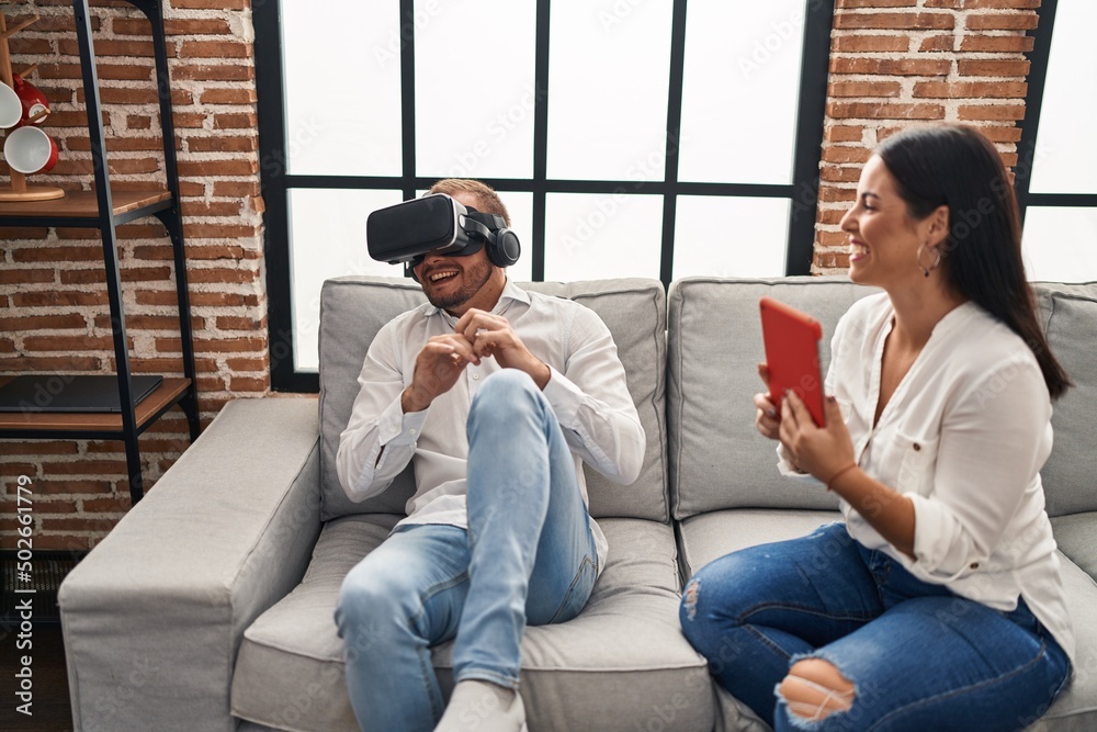 Man and woman couple using touchpad and vr goggles at home Stock Photo ...