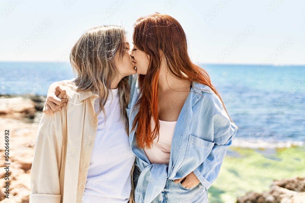 Young lesbian couple of two women in love at the beach. Beautiful women together at the beach in ...