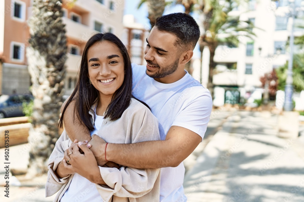 Young latin couple smiling happy and hugging at the city. Stock Photo ...