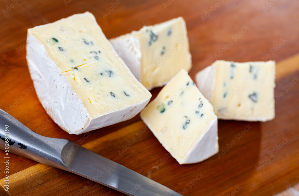 Appetizing cheese Bavaria blu, cut into pieces, with white and blue ...