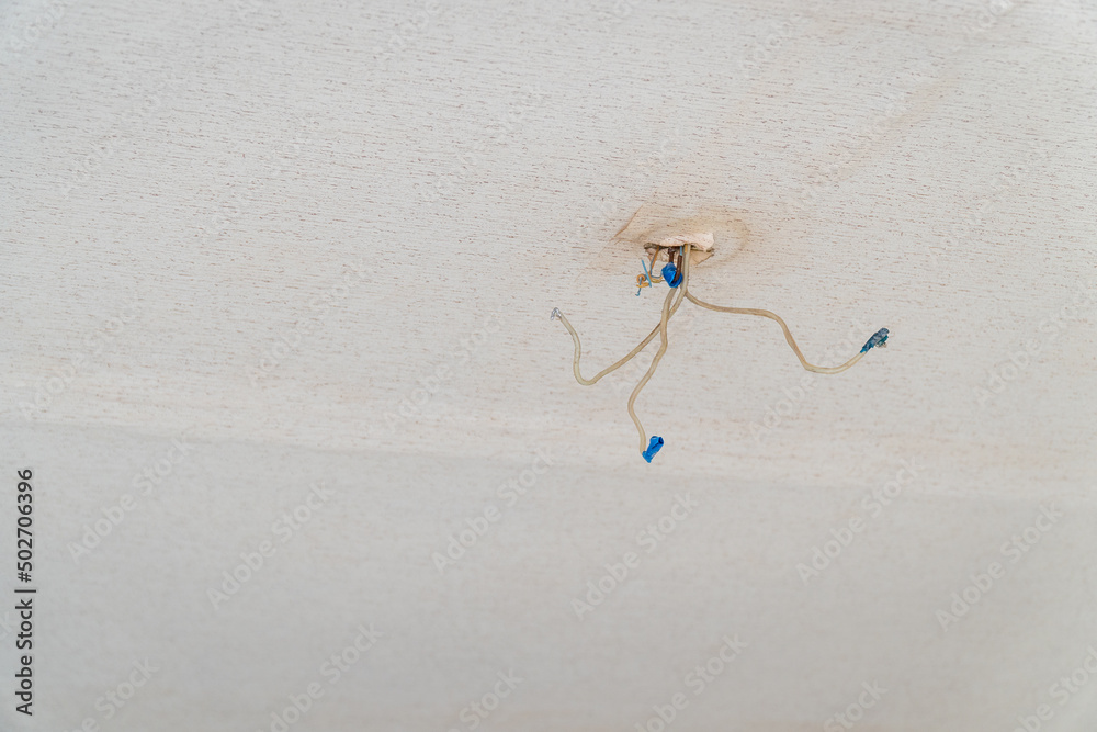 Dangerous bad wiring which hangs on the ceiling Stock Photo | Adobe Stock