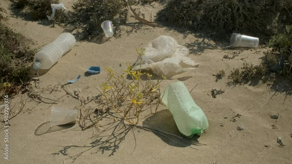 Plastic trash in the desert. Plastic pollution in a sandy desert in ...