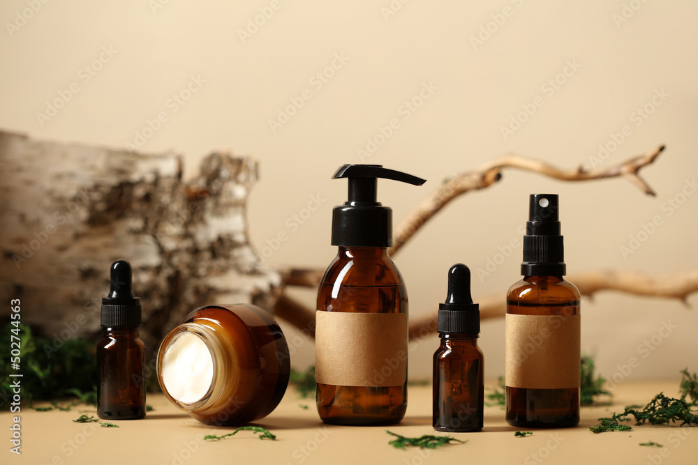 Set of amber glass cosmetic bottles with bark of birch, wood branch ...