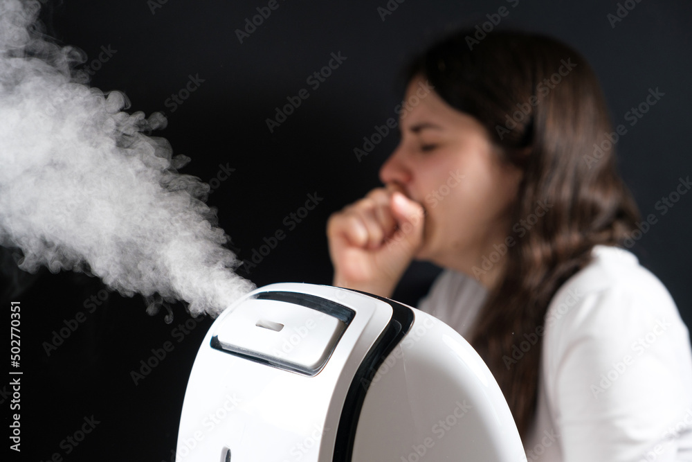 Humidifier and coughing woman in the background. Humidification of the ...