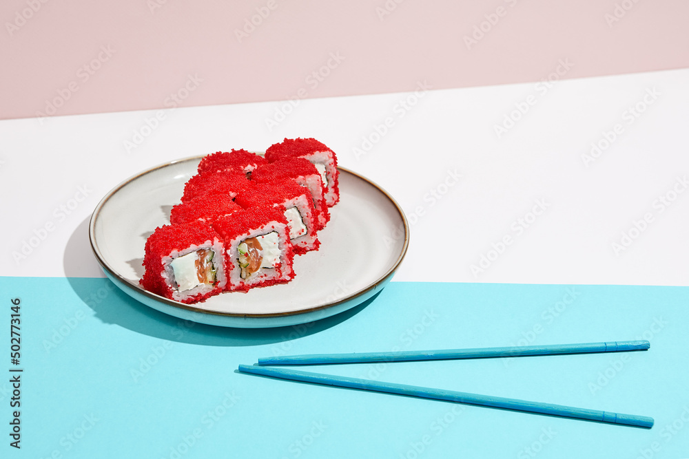 California maki roll with tobiko caviar on modern coloured background ...