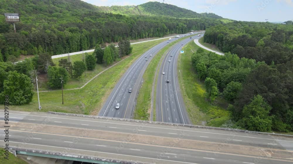 Vehicles driving on the interstate with a curve in the road. An ...