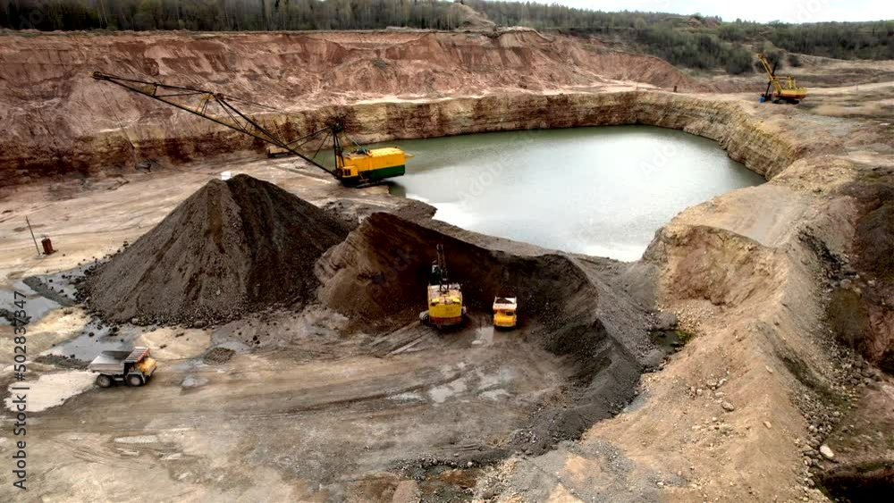 Mining excavator loading dolomite minerals in haul truck. Limestone ...
