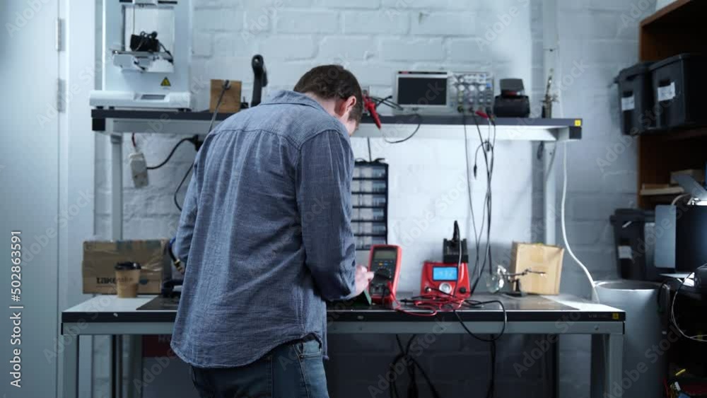 A small workstation with an industrial DIY look. A young man walks to a ...