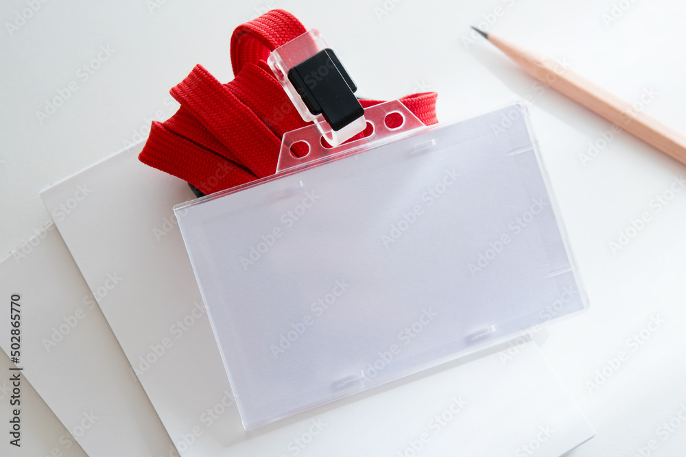 Blank ID or security card on office table, with red neck strap. For ...