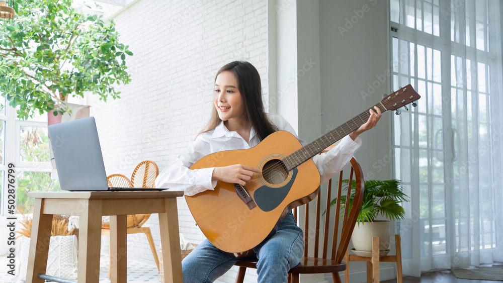 beautiful woman playing guitar happily.Cute Asian woman with attractive ...