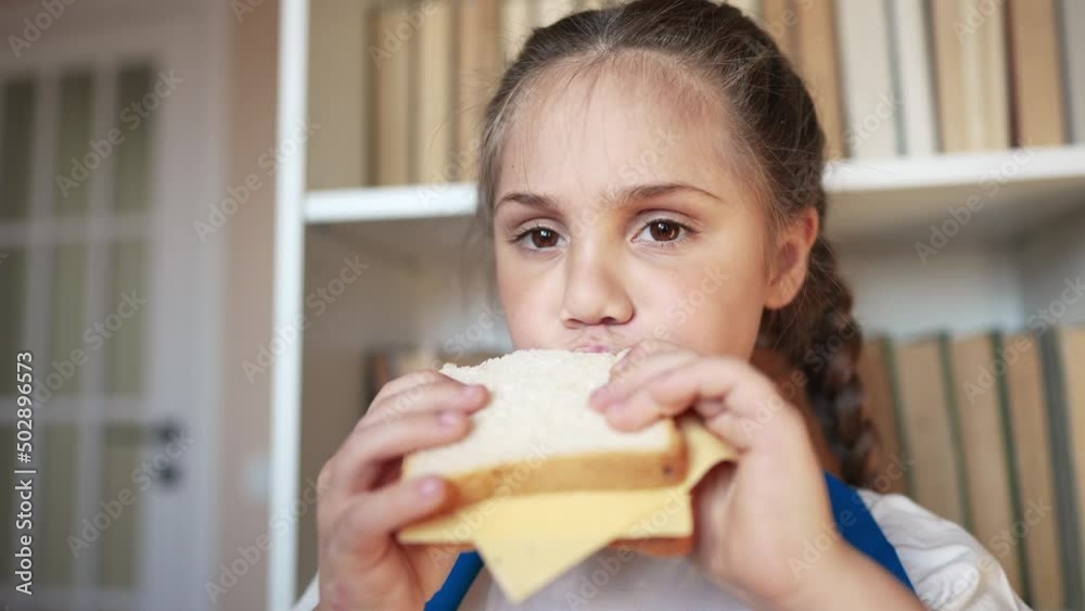 schoolgirl eats a sandwich at school during recess with backpack and ...