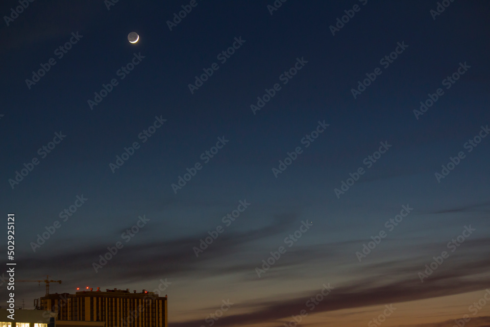 Color photograph of a young waxing moon and the planet Mercury against ...