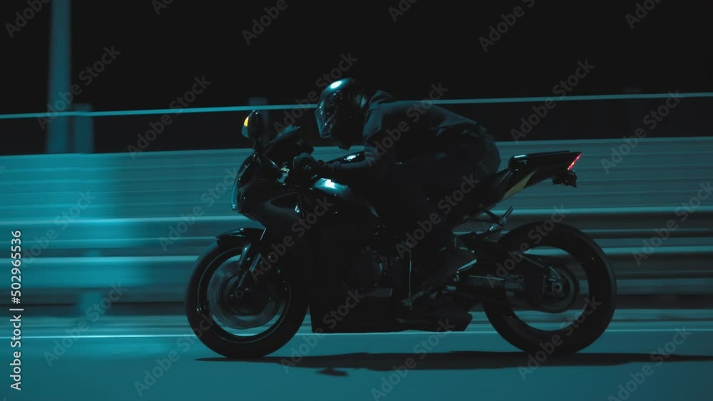 A man rides a sports motorcycle on a night track Stock Video | Adobe Stock
