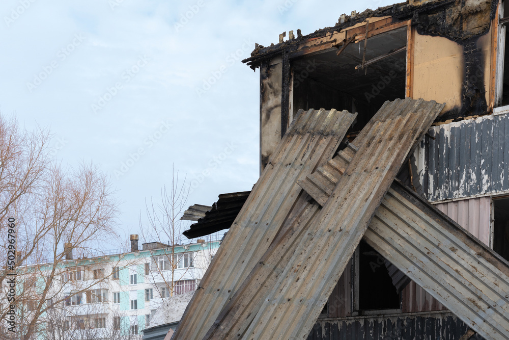 A house after a fire on the background of an entire apartment building ...